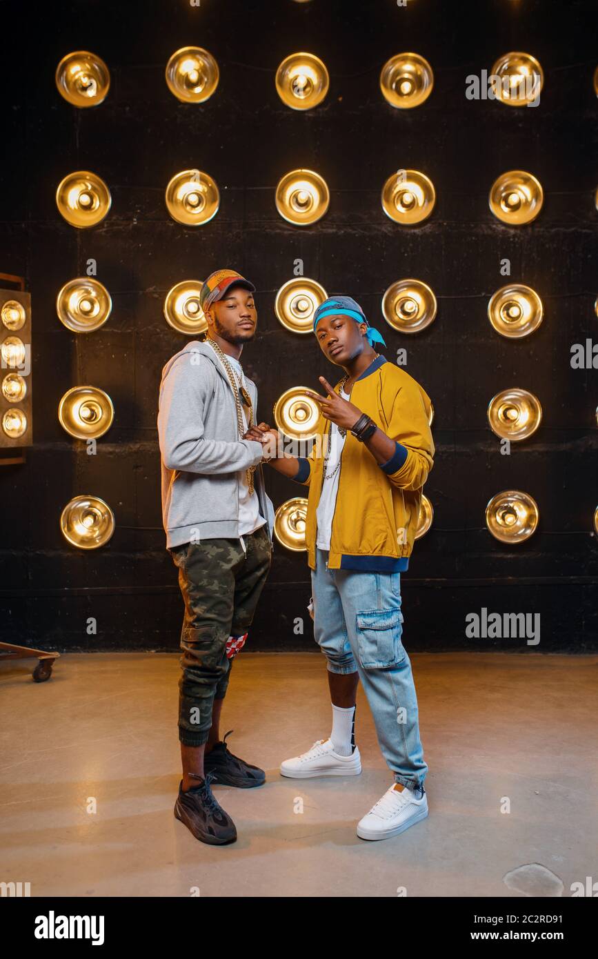 Two black rappers in caps, artists poses on stage with spotlights on ...