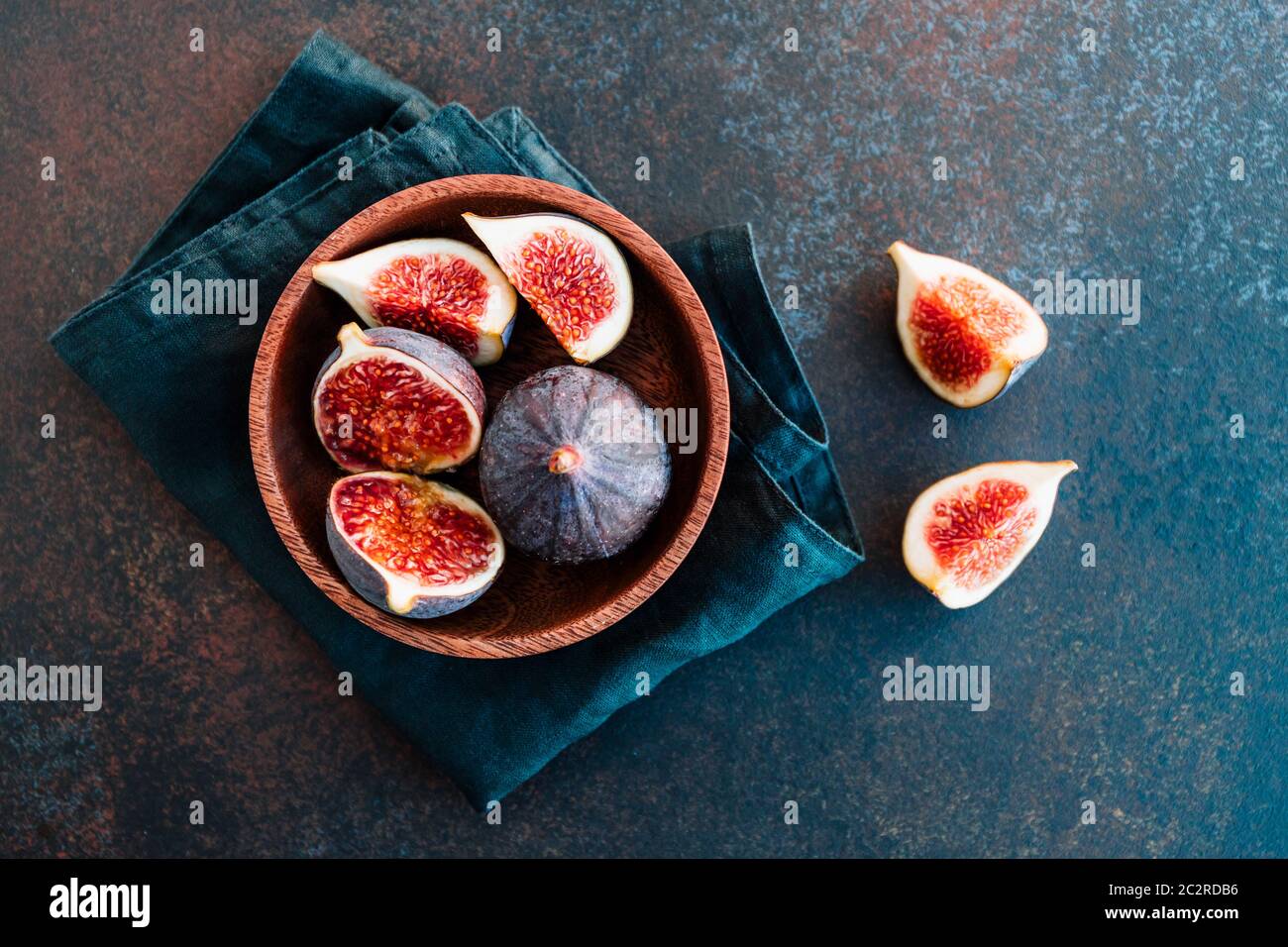 Top view of ripe figs in a wooden bowl over dark blue background Stock ...
