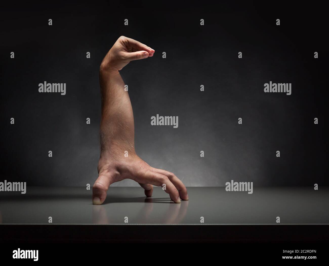 Strange human hand creature on the grey table Stock Photo - Alamy