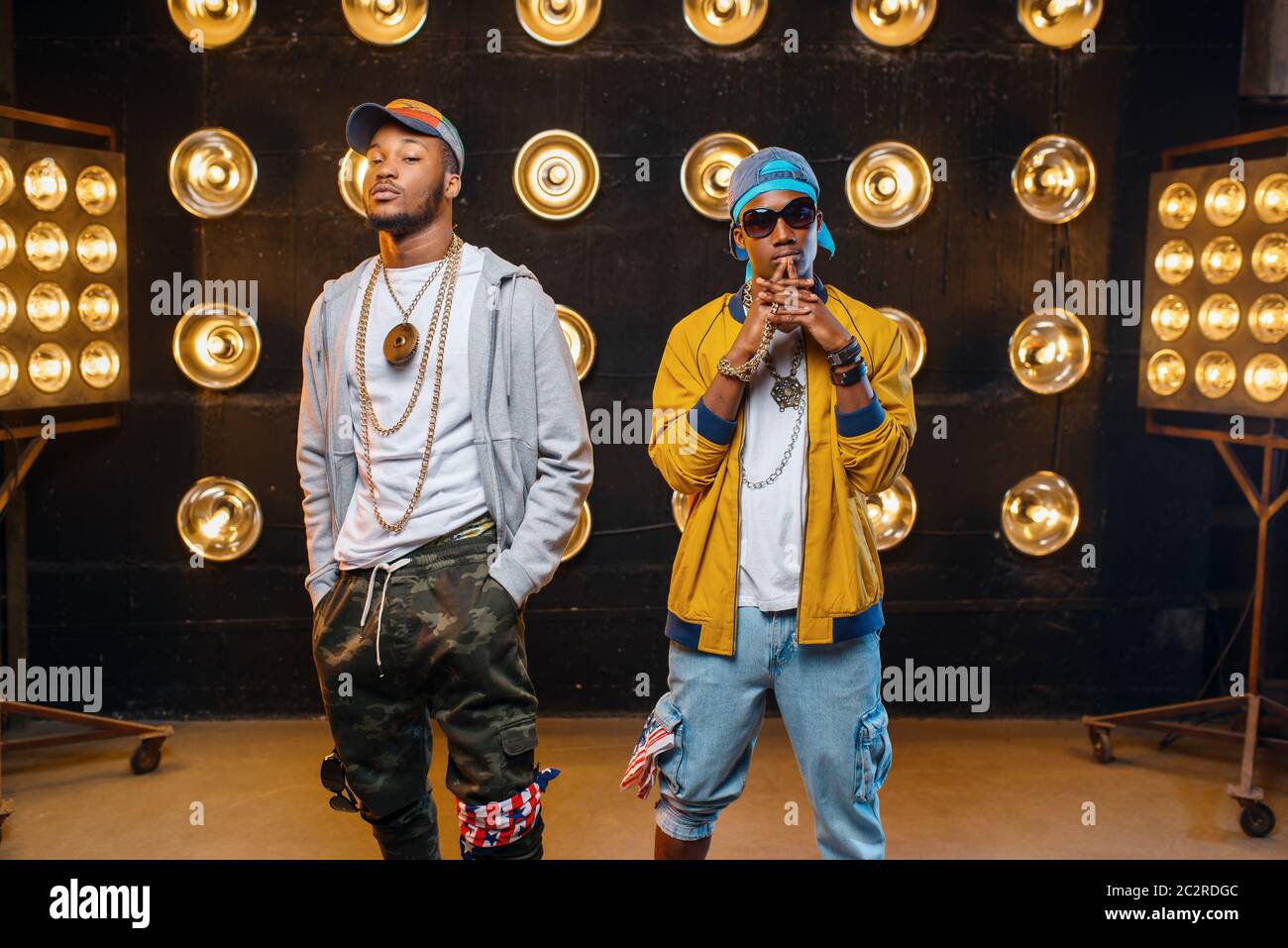 Two black rappers in caps, perfomance on stage with spotlights on ...