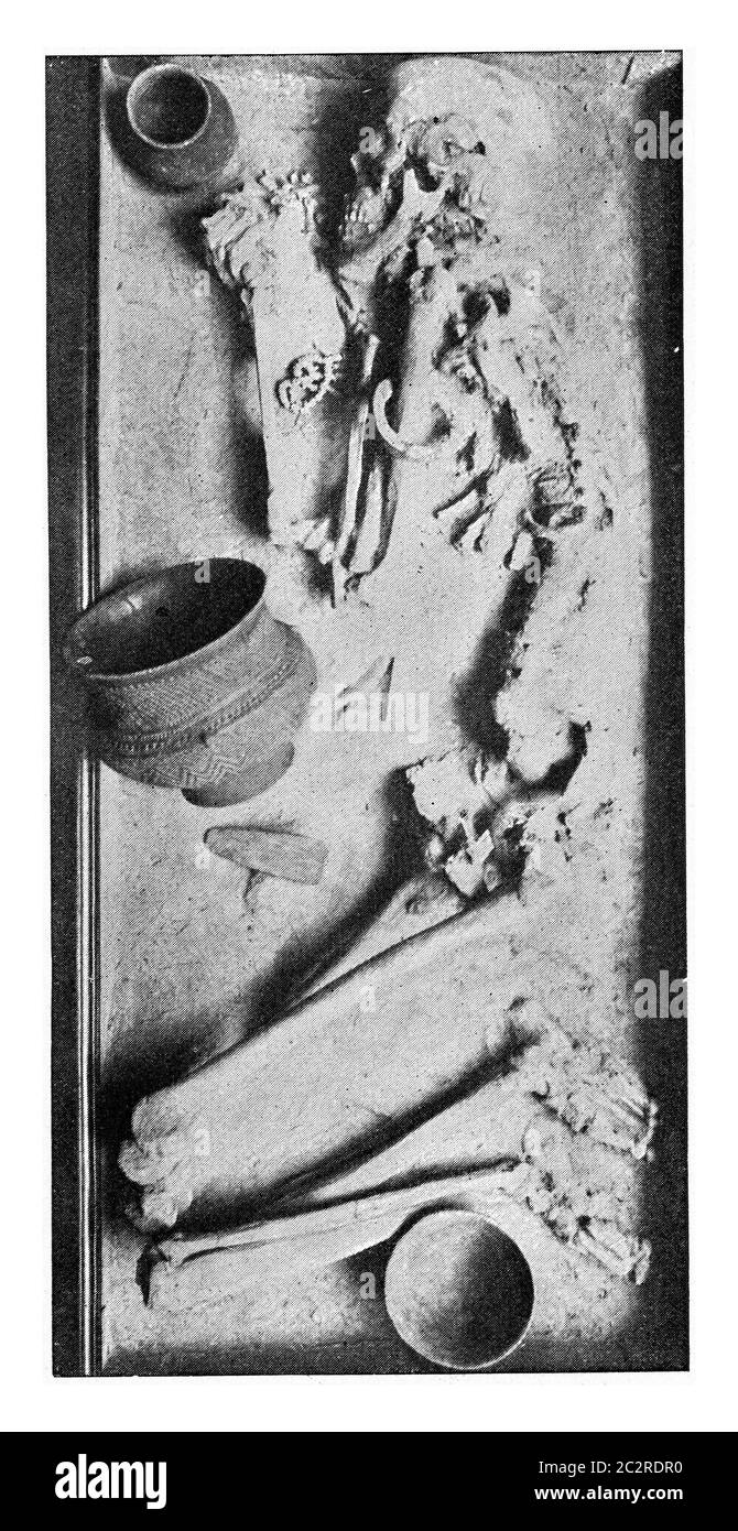 Skeleton of the recent stone age with vases, flint tools, bone bracelet ...
