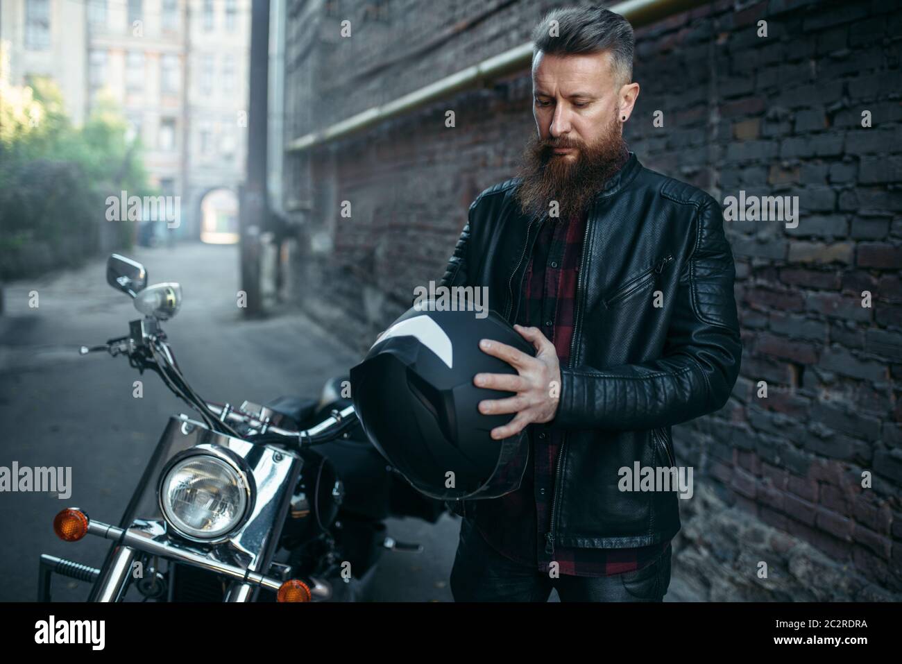 Biker puts on helmet before riding on classical chopper. Vintage bike ...