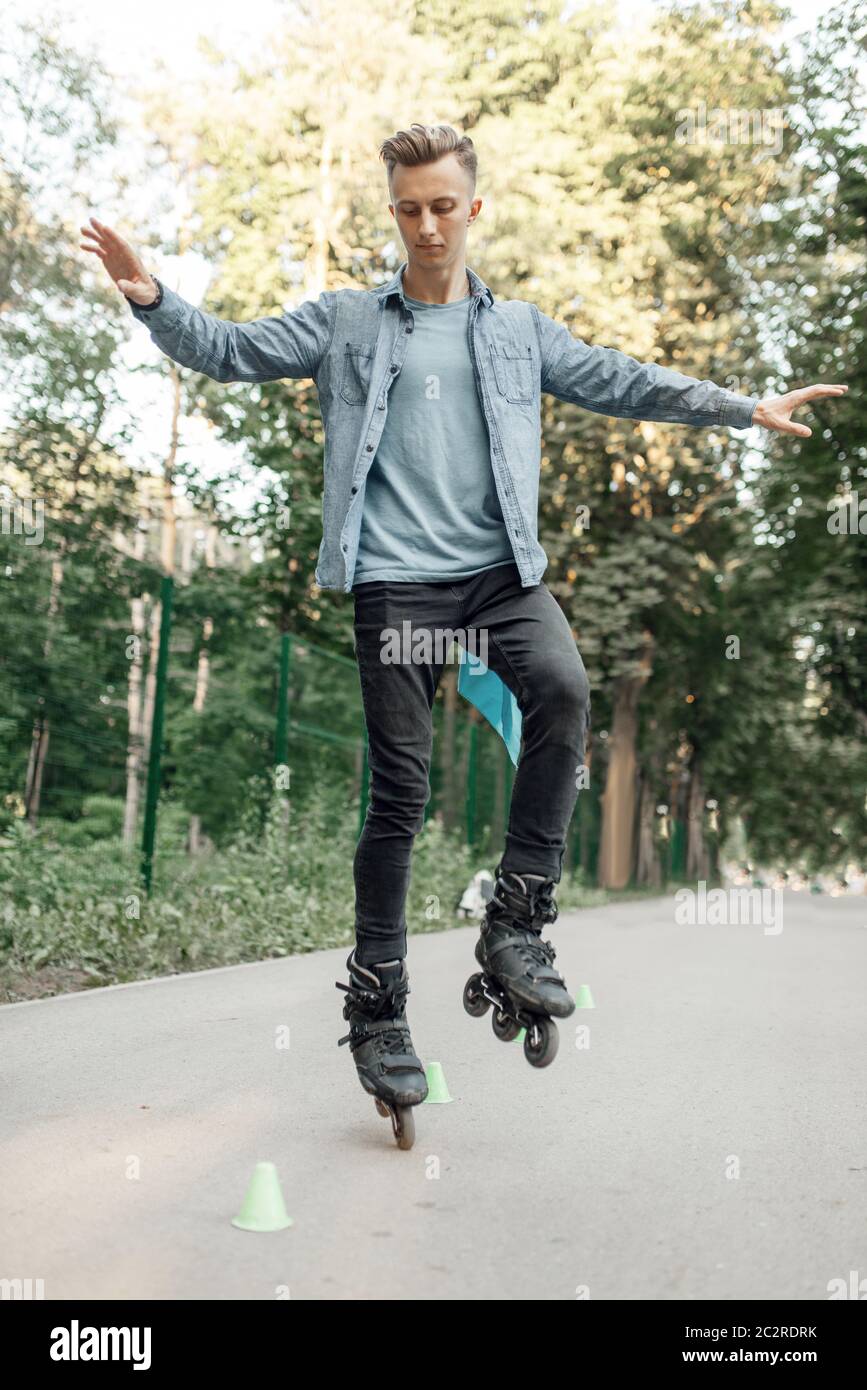 Roller skating, male teenager rolling on one leg in park. Urban roller ...