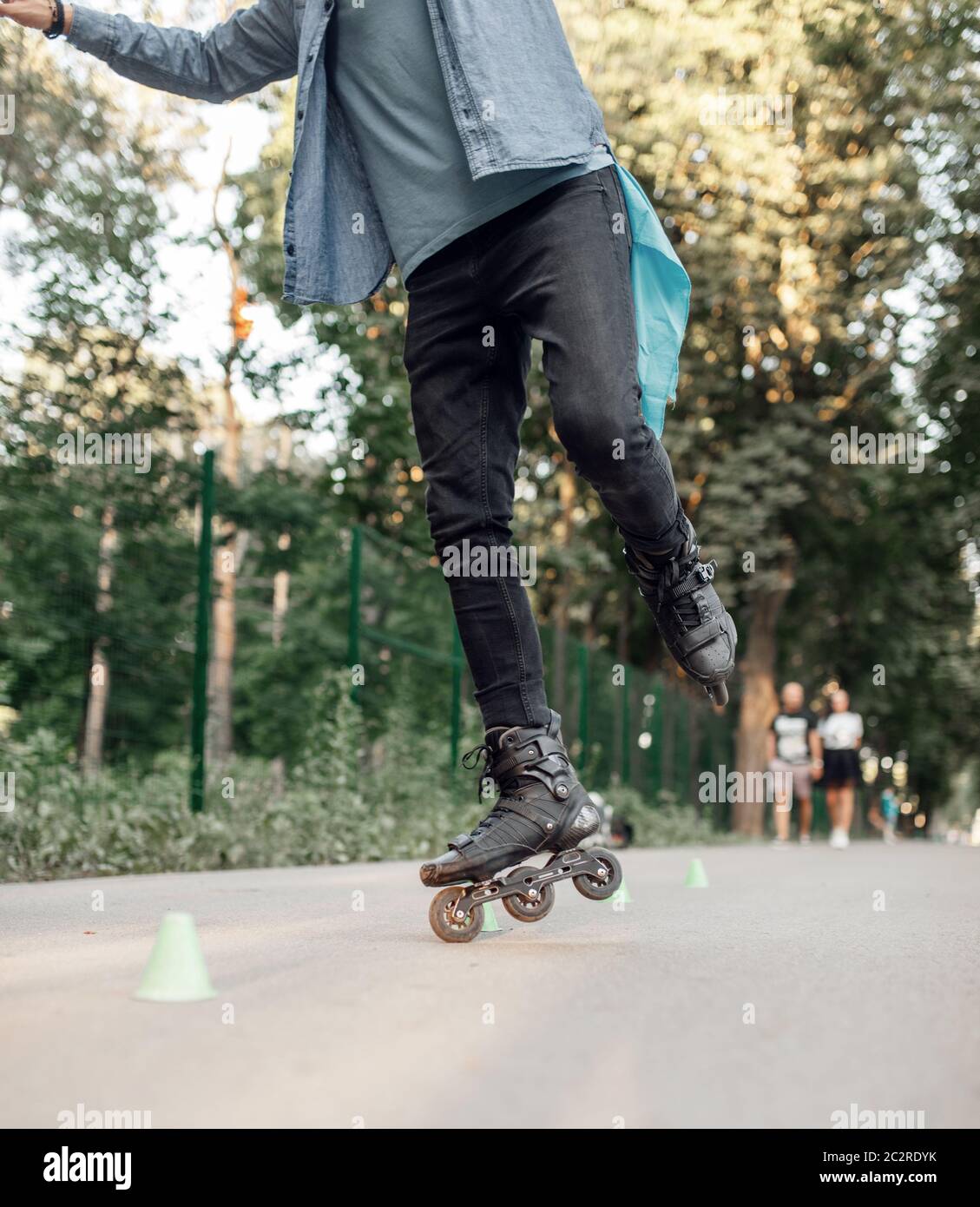 Roller skating, male teenager rolling on one leg in park. Urban roller ...