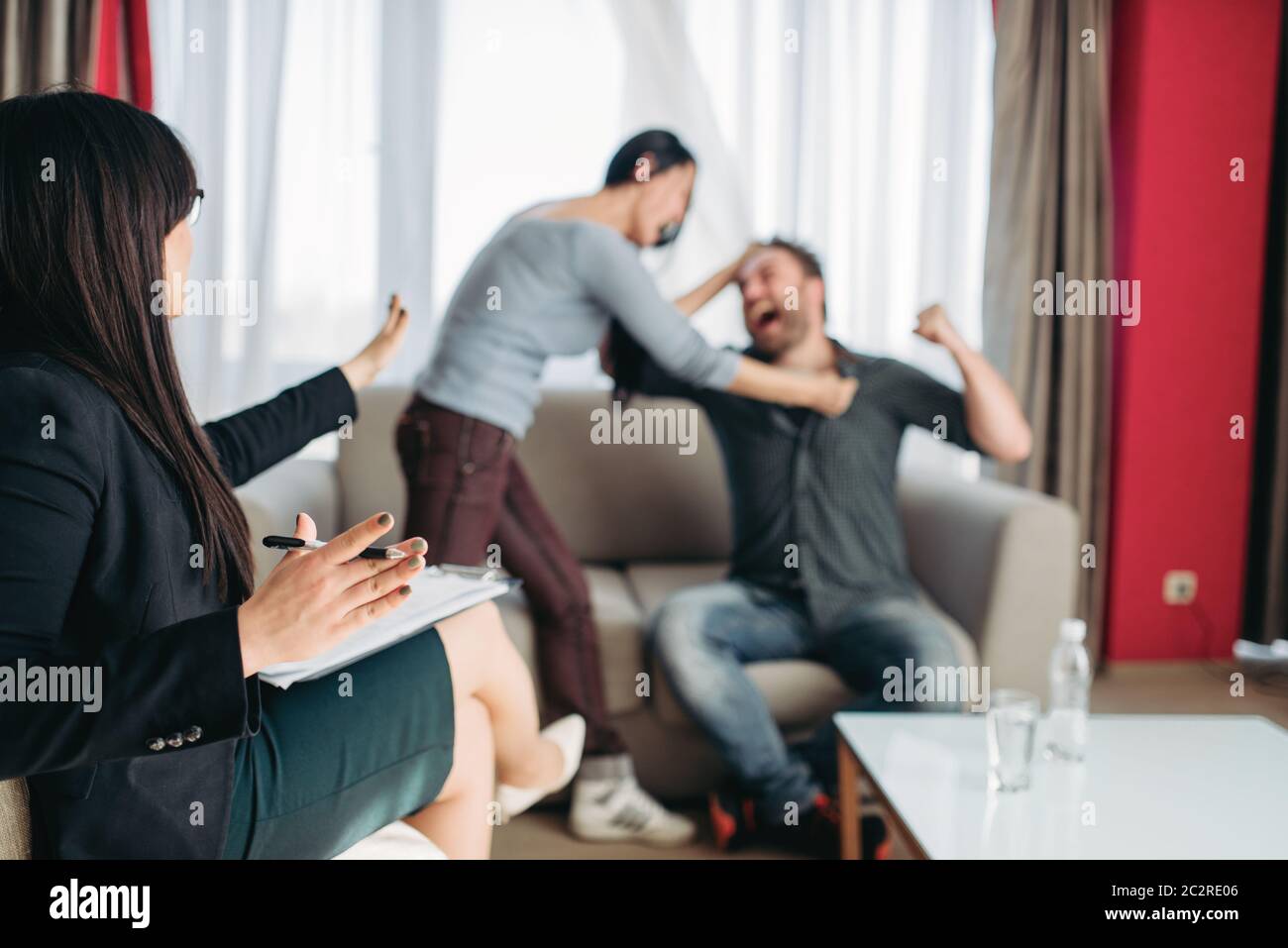 Mad couple fights at psychotherapist reception. Female doctor helps ...