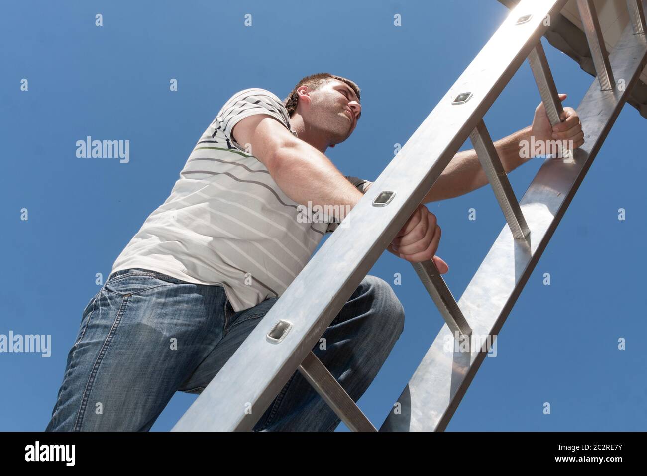 Man climbing on the ladder over sky background Stock Photo - Alamy