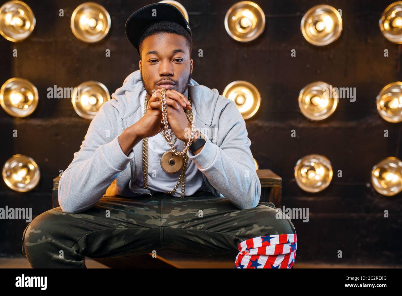 Black rapper in cap poses, perfomance on stage with spotlights on ...