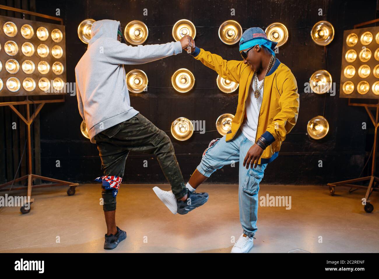 Two black rappers in caps hugging on stage, perfomance in club with ...