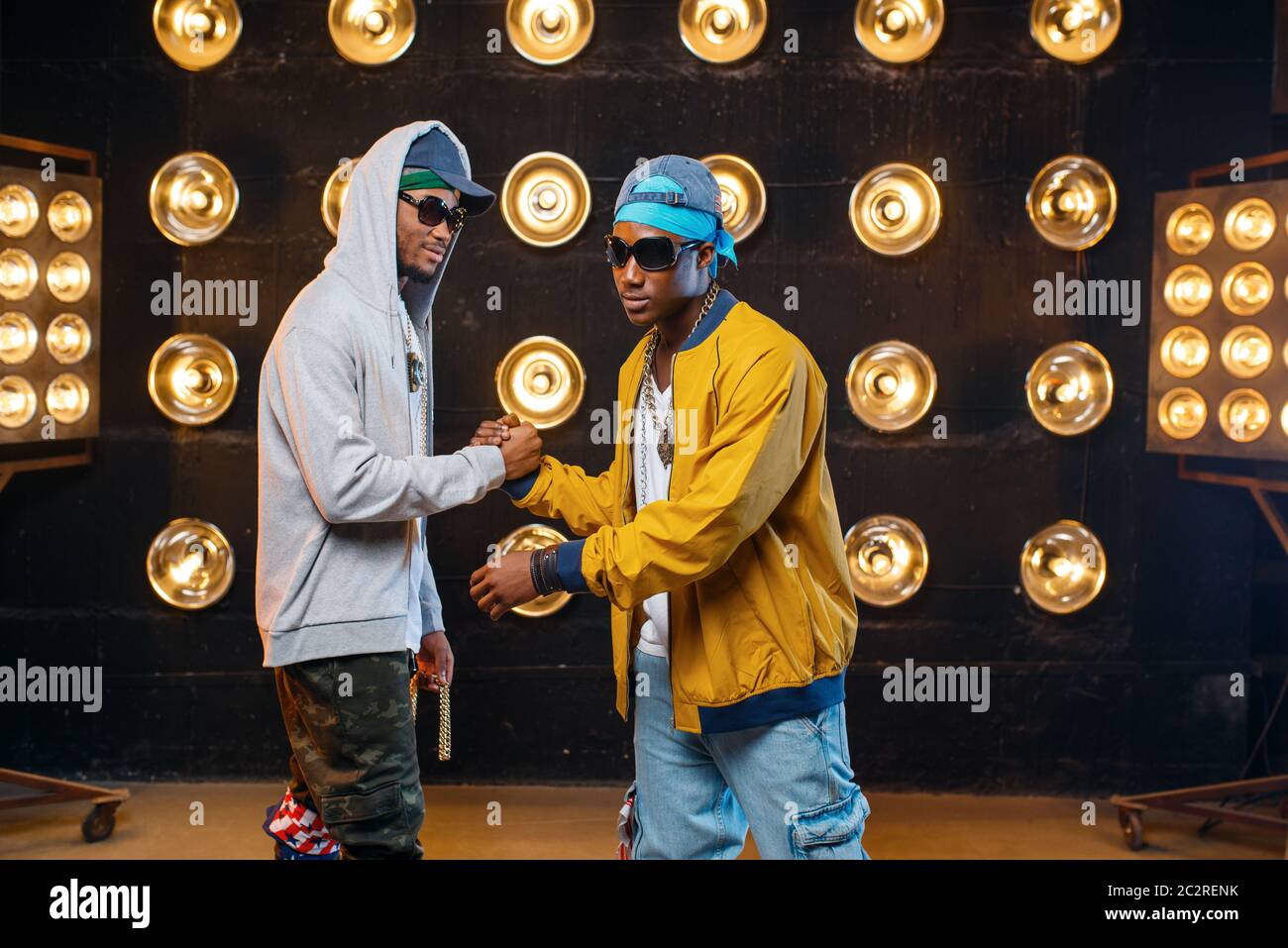 Two black rappers in caps hugging on stage, perfomance in club with ...