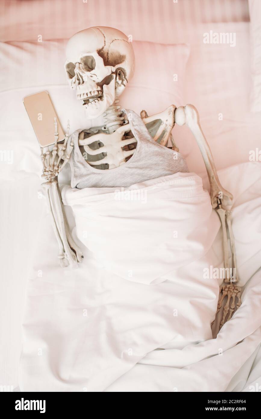 Skeleton in bed with phone hi-res stock photography and images - Alamy