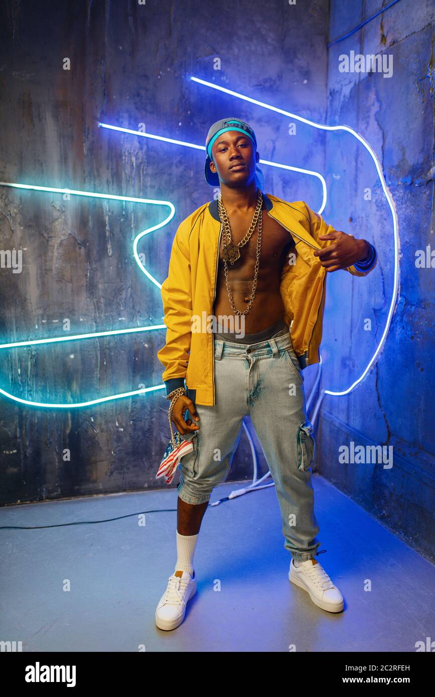 Black rapper in underpass neon light on background. Rap performer in ...