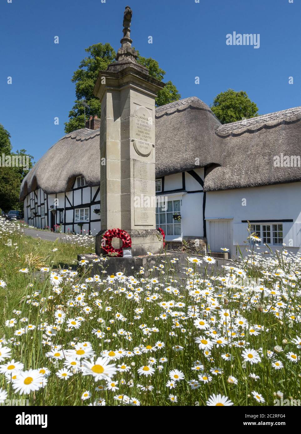 Thatched cottages and war memorial monument in the picturesque village ...