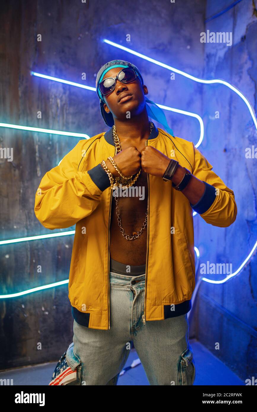 Black rapper in underpass neon light on background. Rap performer in ...