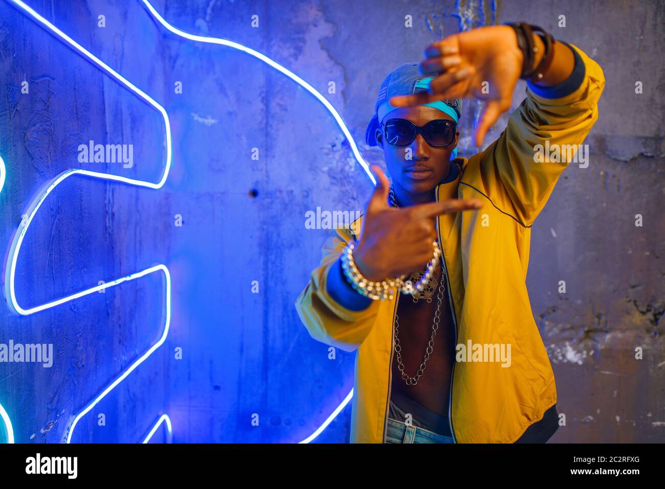 Black rapper in underpass neon light on background. Rap performer in ...