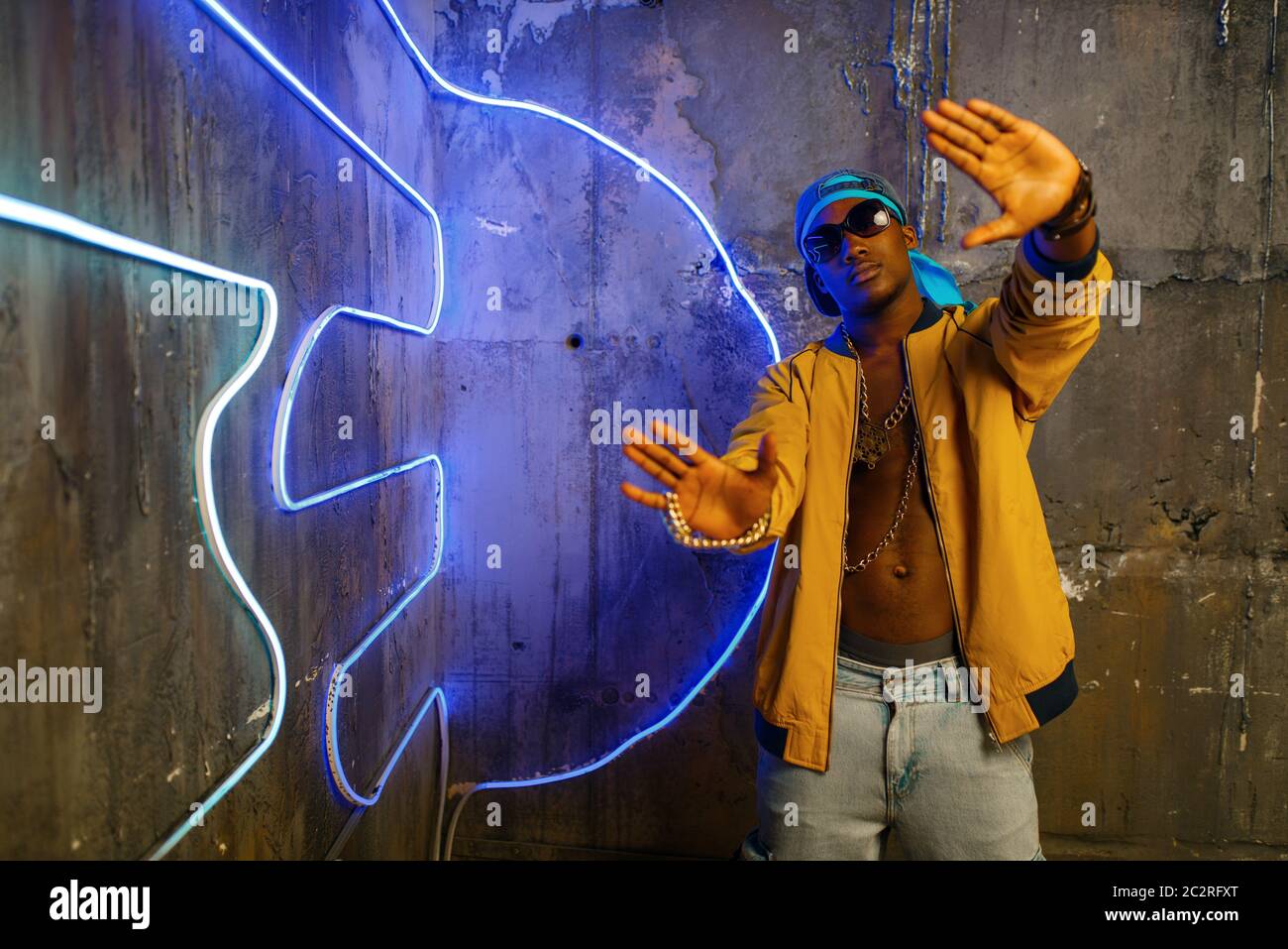Black rapper in underpass neon light on background. Rap performer in ...