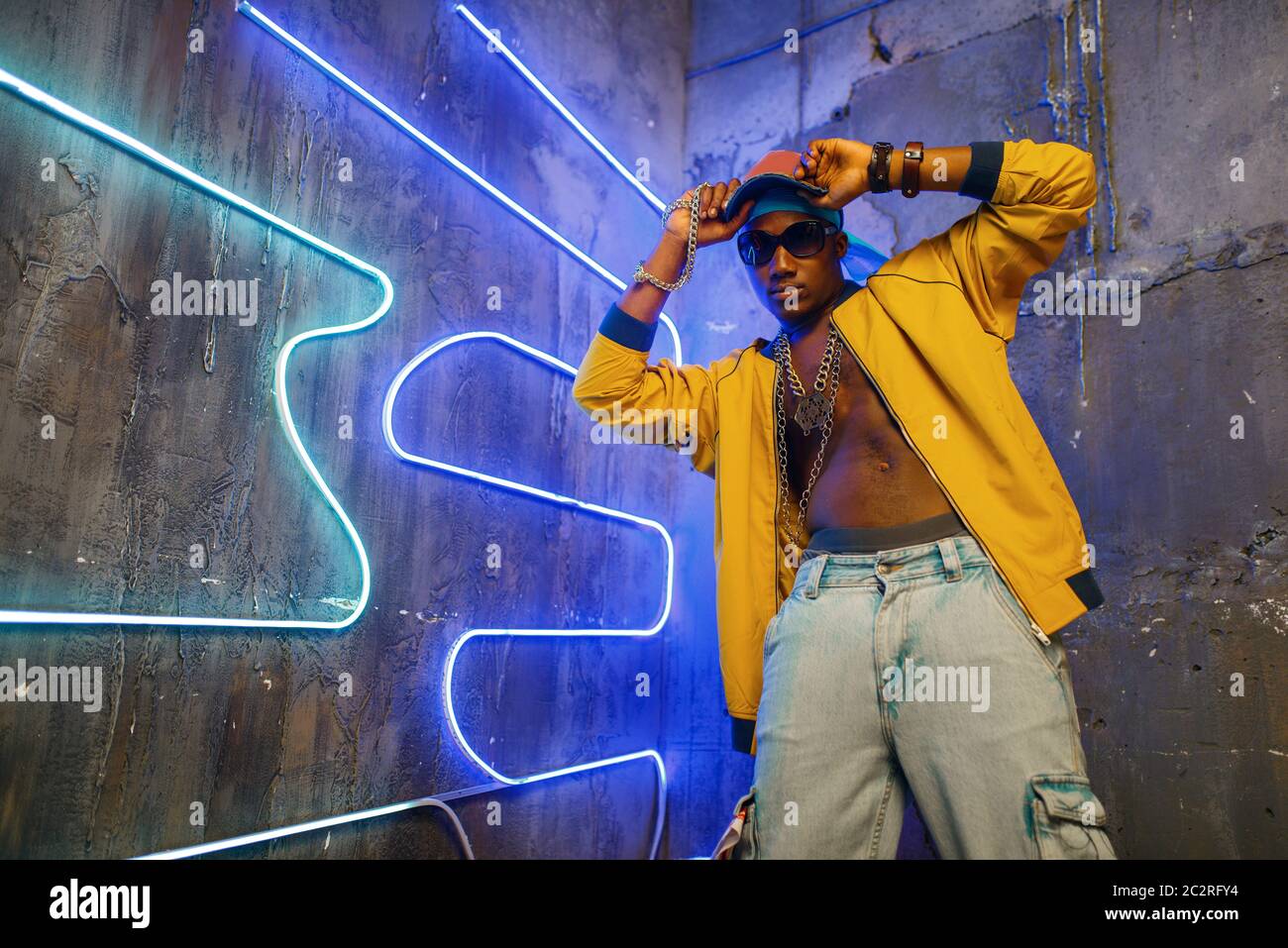 Black rapper in underpass neon light on background. Rap performer in ...