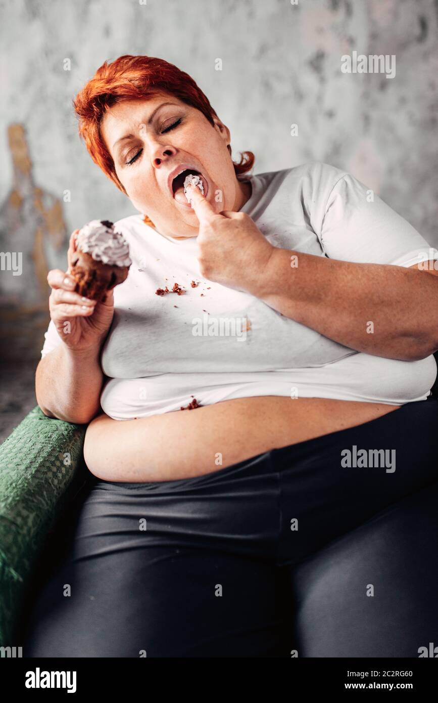 Overweight woman eats sweet cake, laziness and obesity. Unhealthy food ...