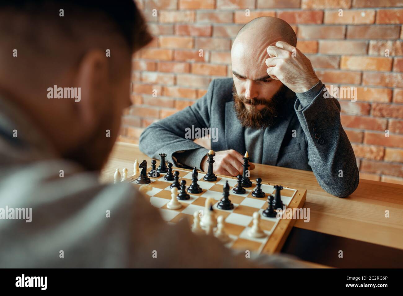 Male chess players playing, thinking process. Two chessplayers begin ...