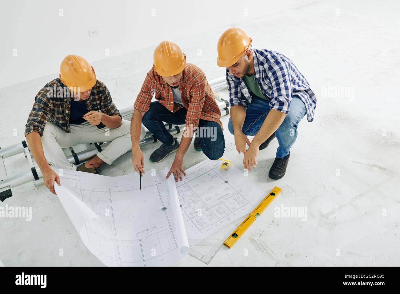 Horizontal high angle shot of modern construction workers sitting on ...