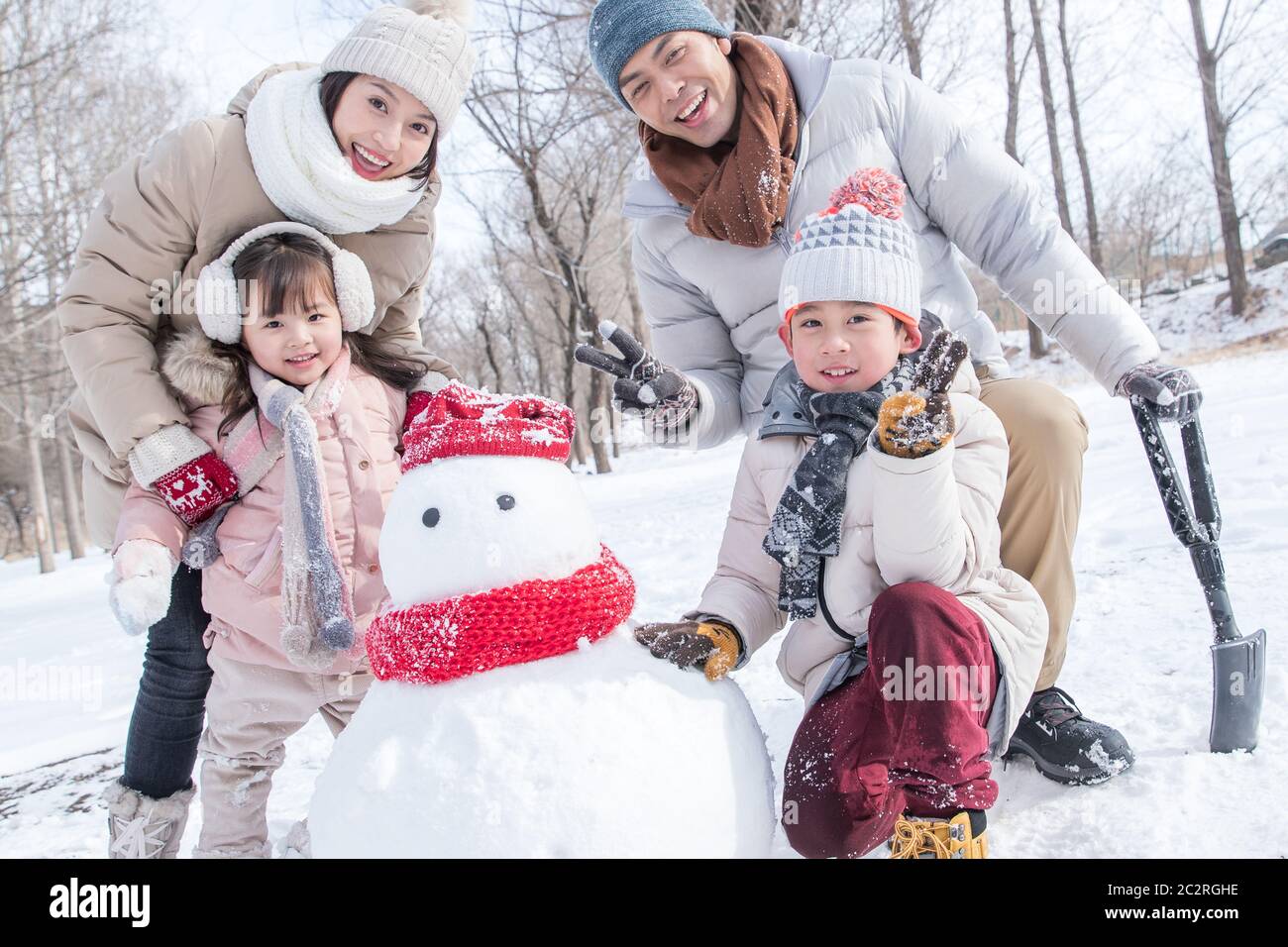 Happy family make a snowman in the snow Stock Photo - Alamy