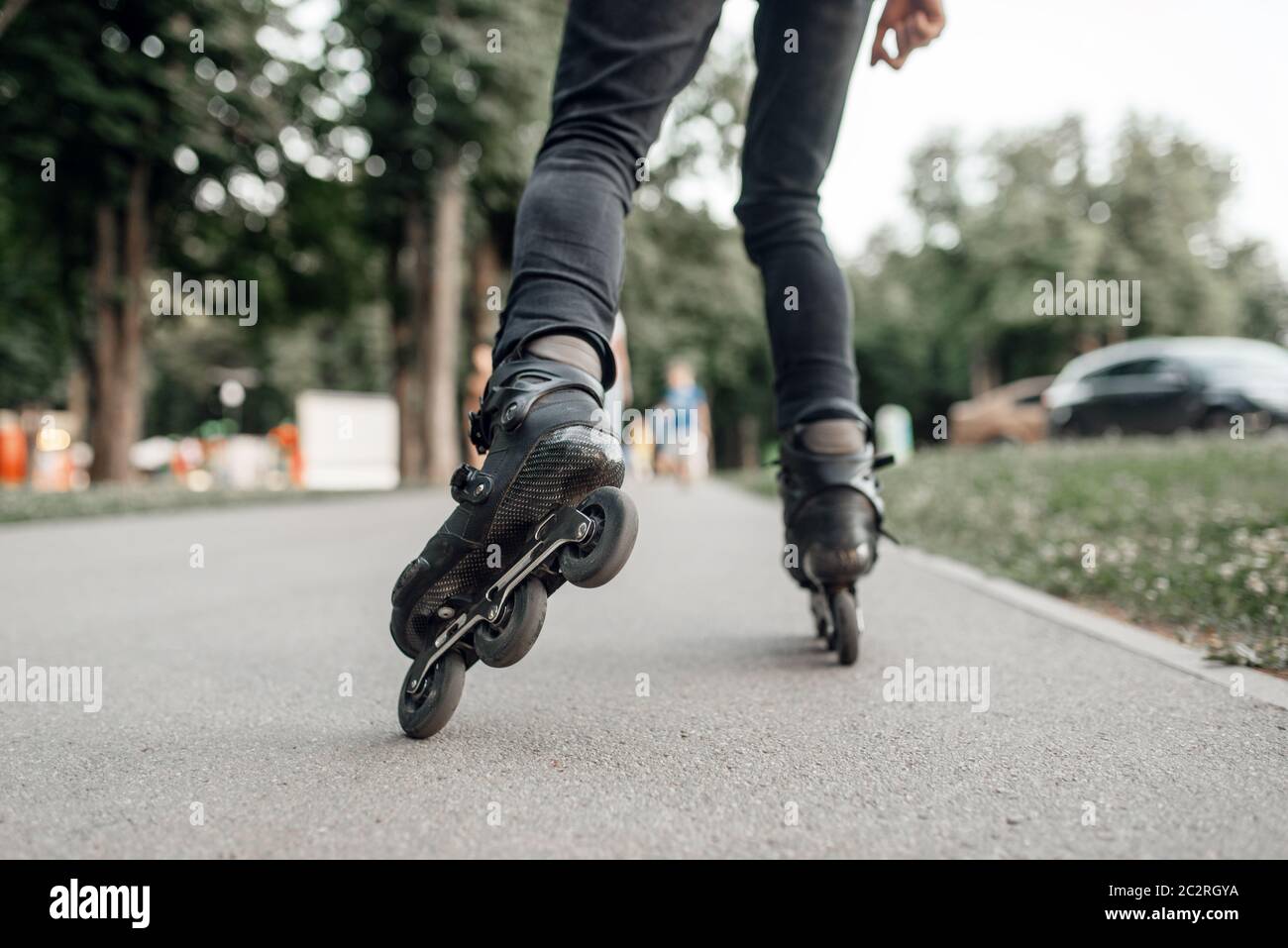 Roller skating, young skater rolling in summer park, back view on legs ...