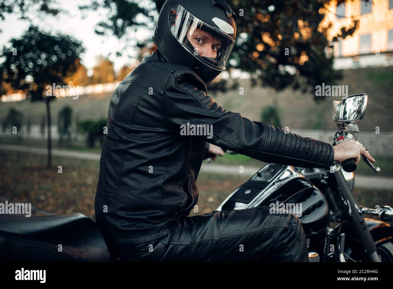 Biker in helmet poses on a motorcycle, classical chopper. Vintage bike ...