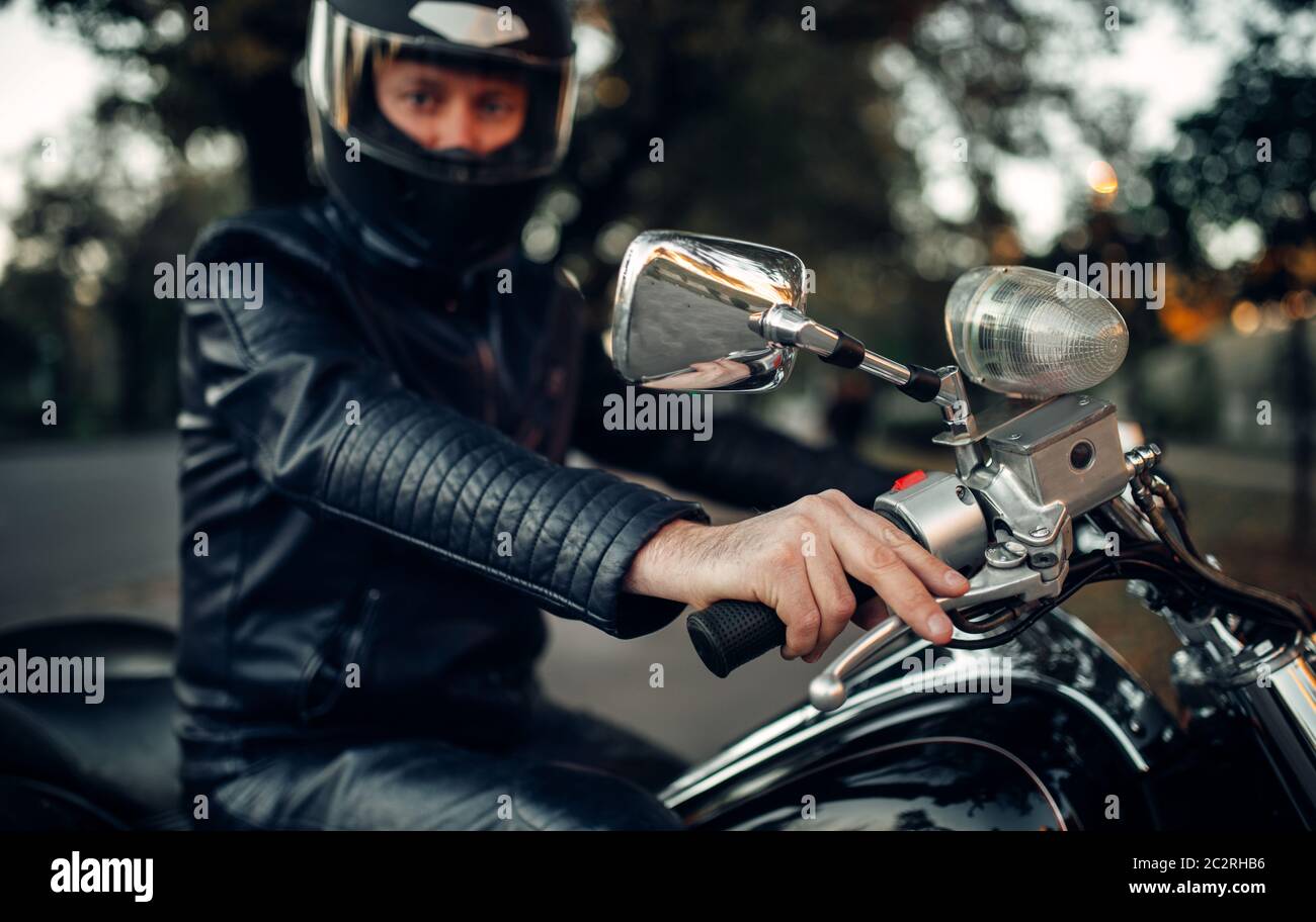 Biker in helmet poses on a motorcycle, classical chopper. Vintage bike ...