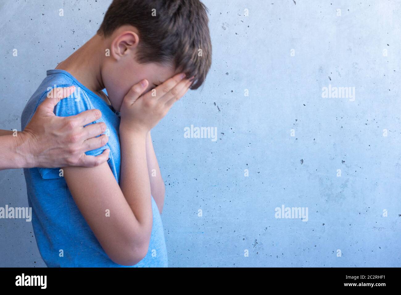 Mother hand hugging sad boy. Learning difficulties, family problems ...