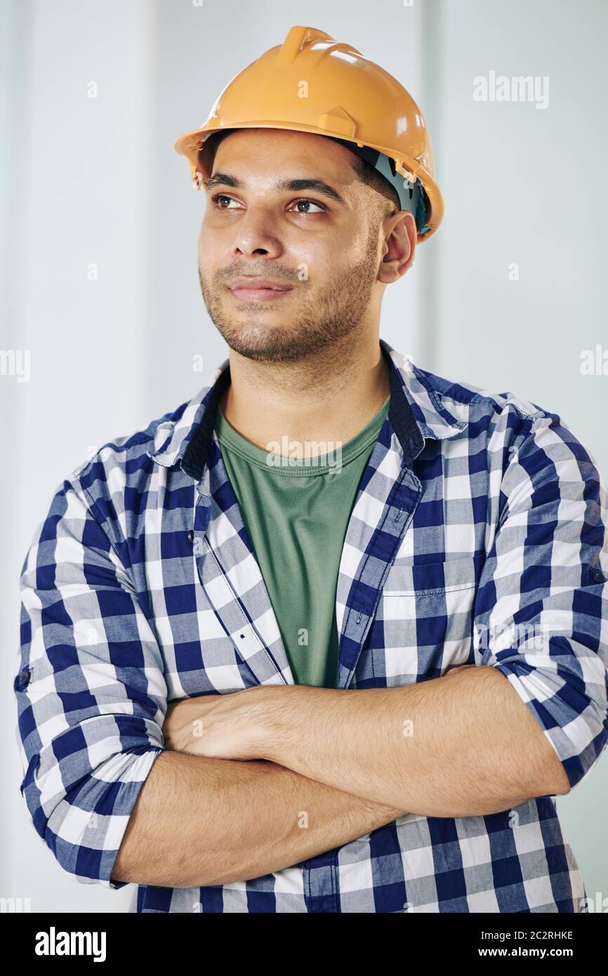 Waist up shot of young adult construction engineer wearing checked ...