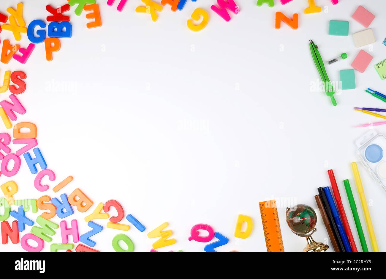 multicolored English alphabet letters and school supplieson a white ...