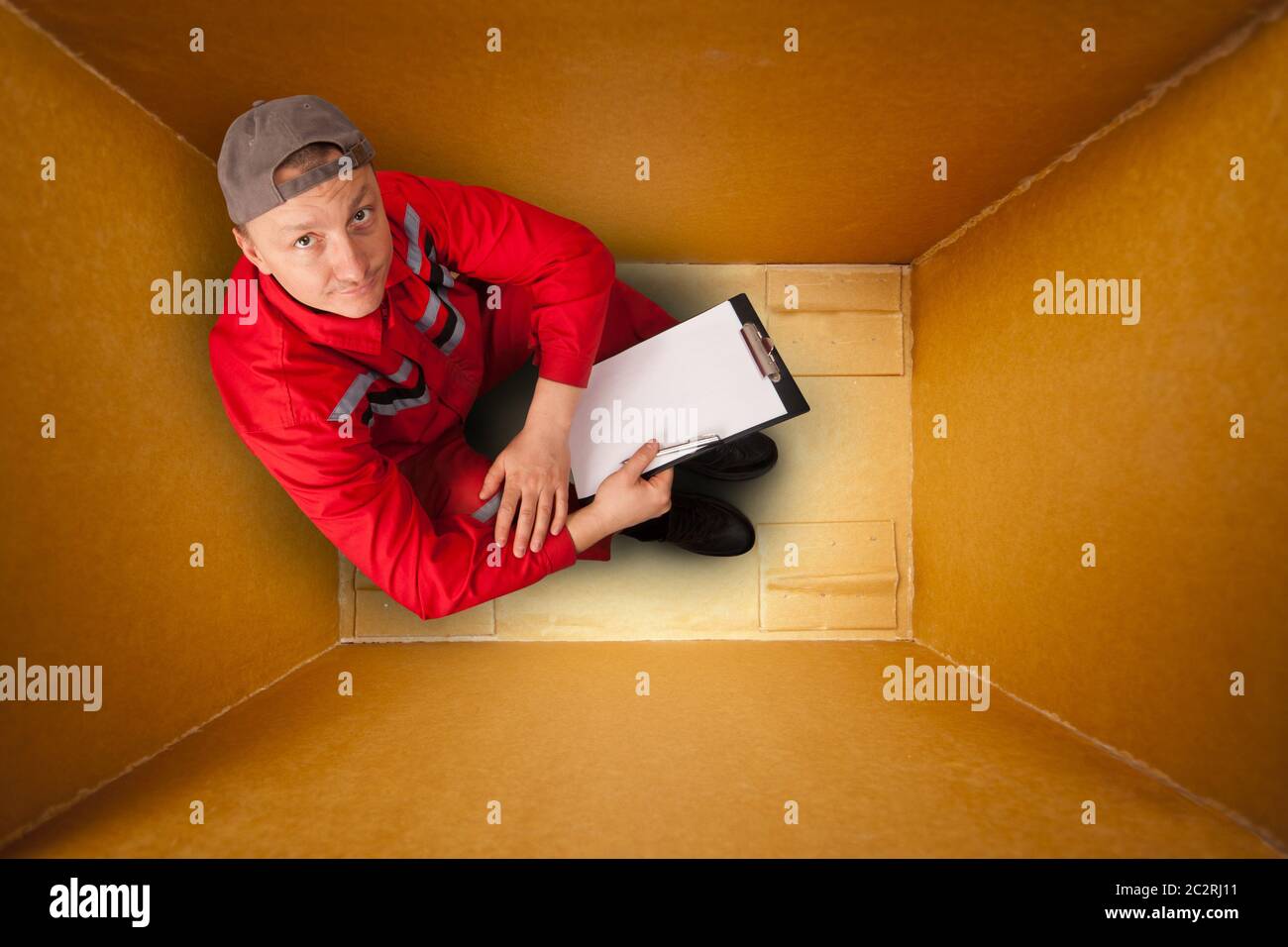 Sad mail courier sitting inside empty box Stock Photo - Alamy