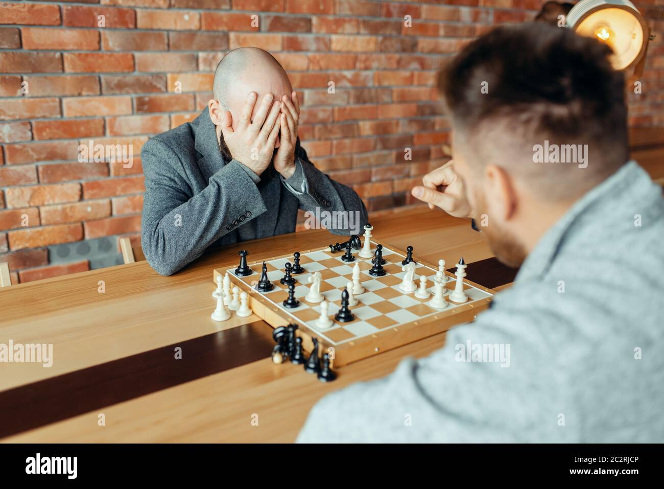 Male chess players playing at board, white wins, mate. Two chessplayers ...