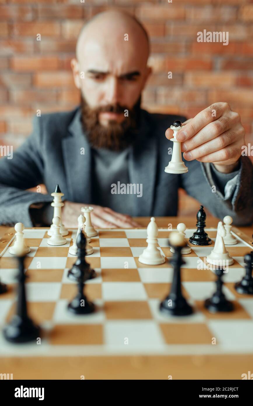 Male chess player playing white figures, queen move. Chessplayer at ...