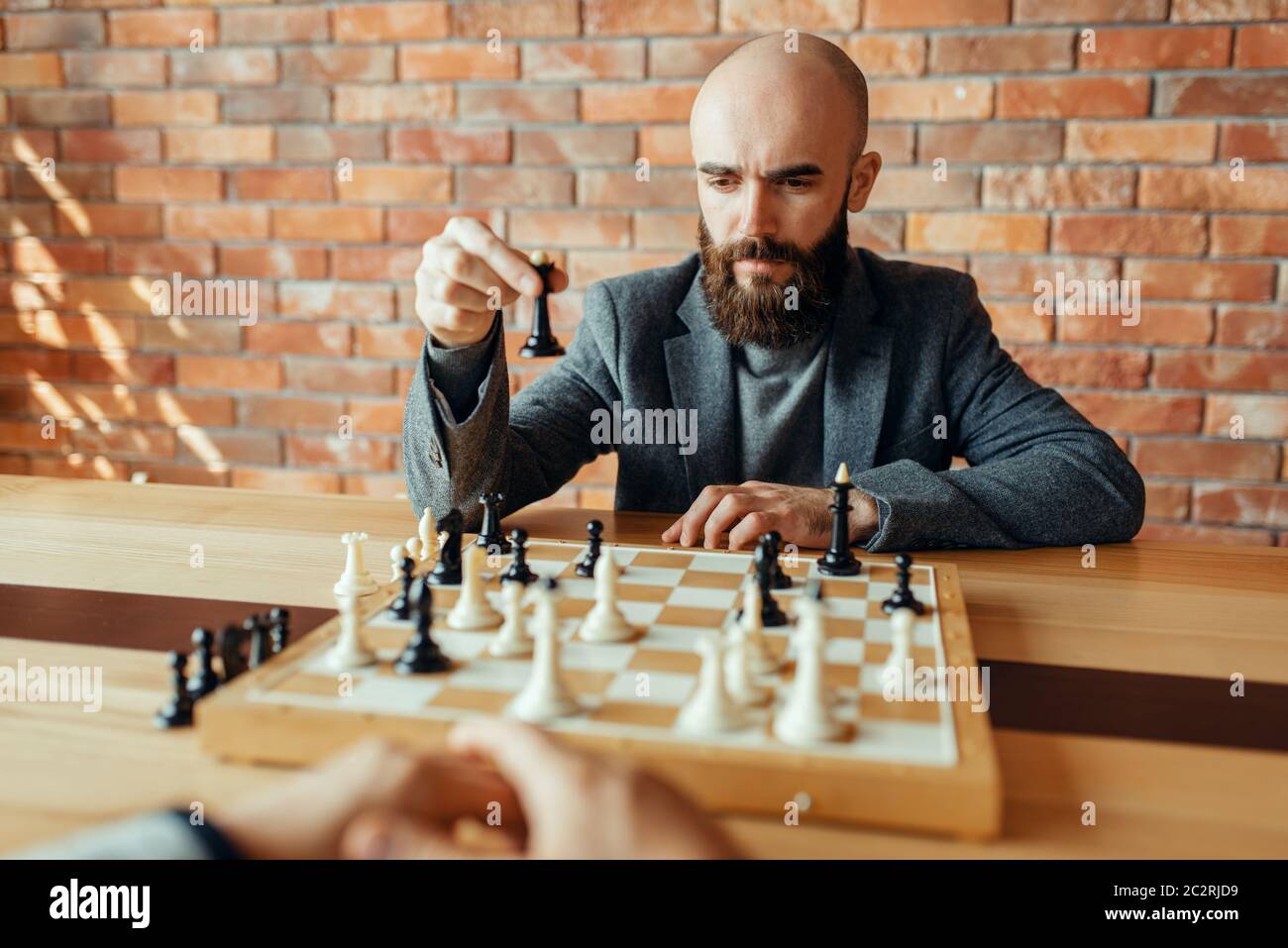 Male chess player playing black figures, queen move. Chessplayer at ...