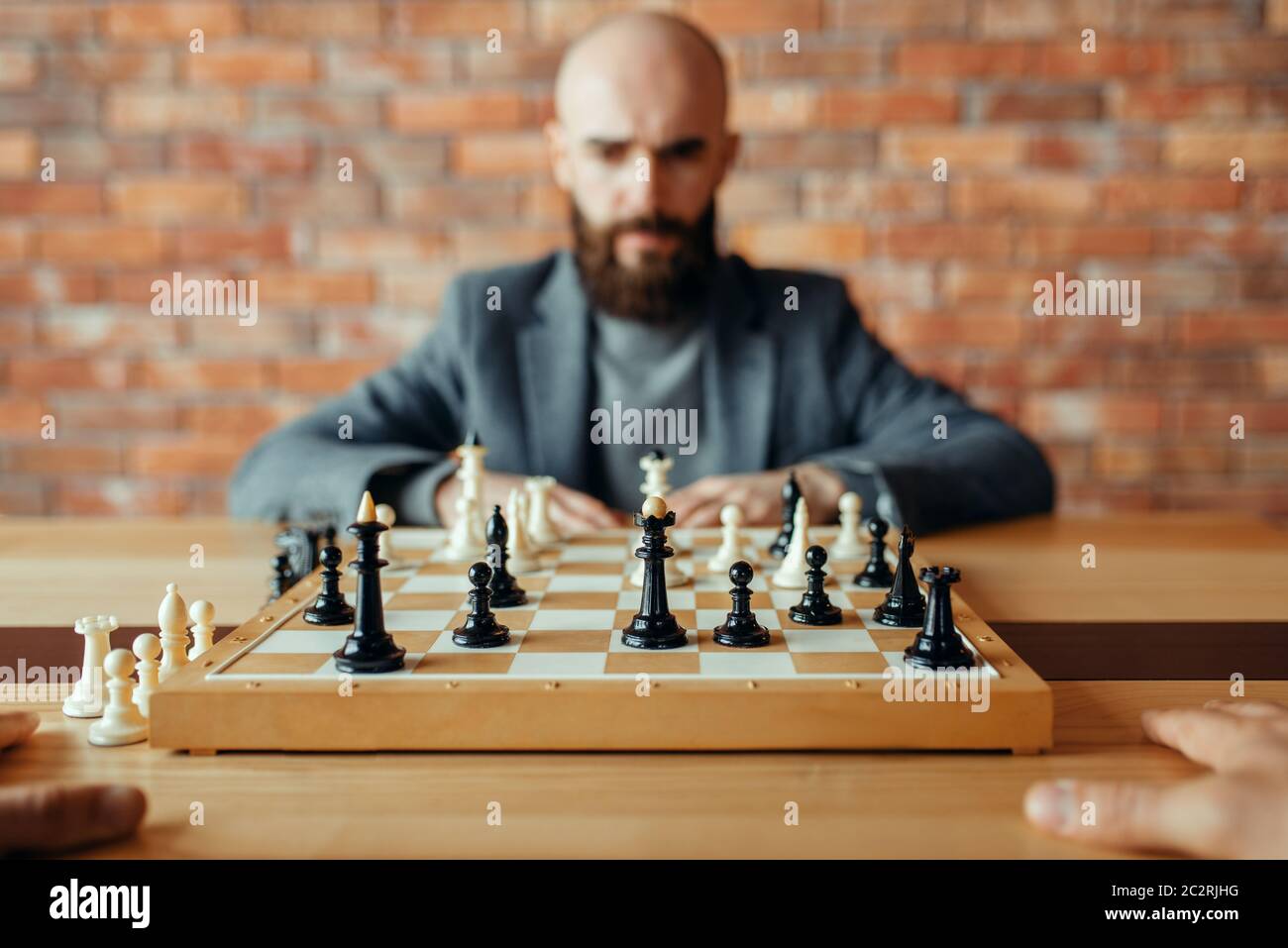 Male chess player, thinking process. Two chessplayers begin the ...