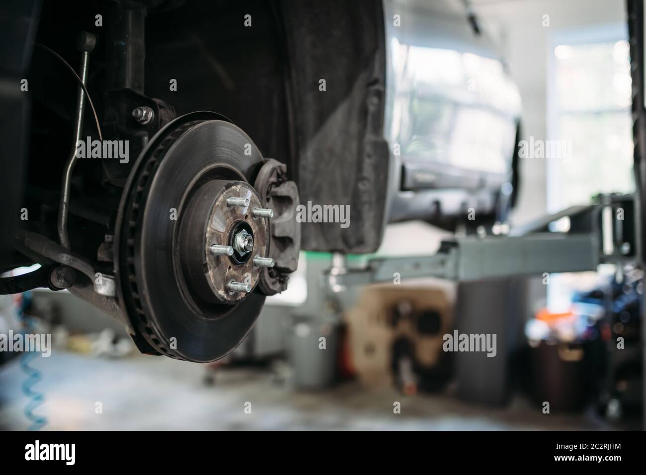 Car with removed wheel on the lift, brake disc. Automobile repair ...