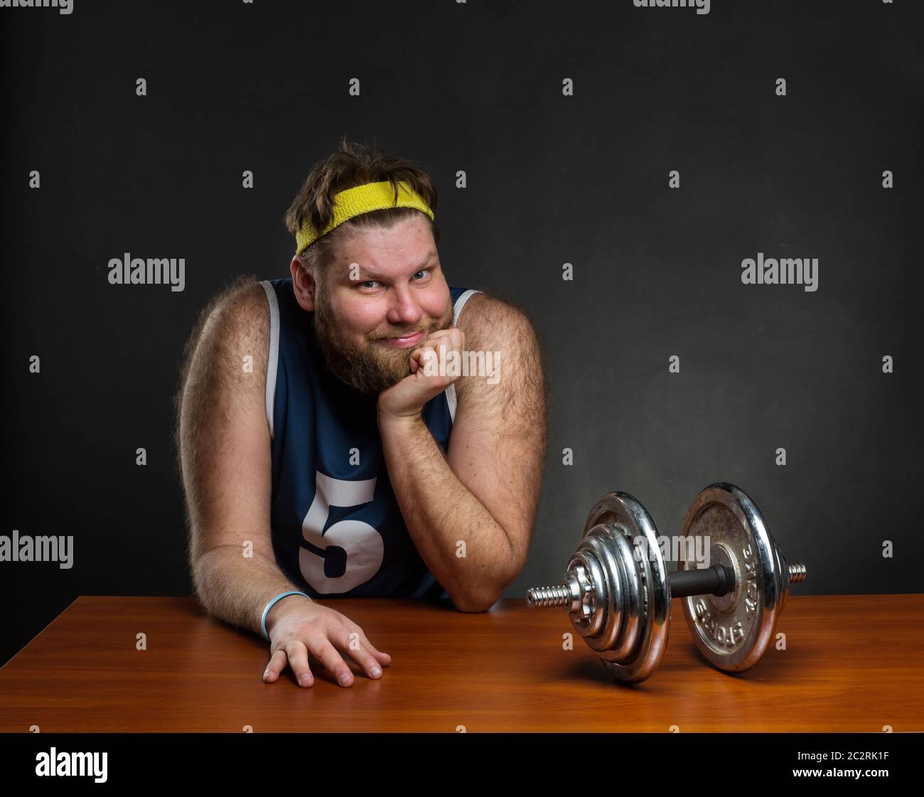 Happy overweight man with a dumbbell at the table Stock Photo - Alamy
