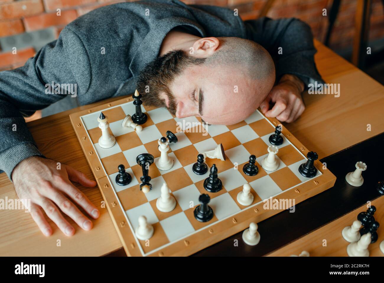 Tired male chess player sleeping on the board. Chessplayer playing ...