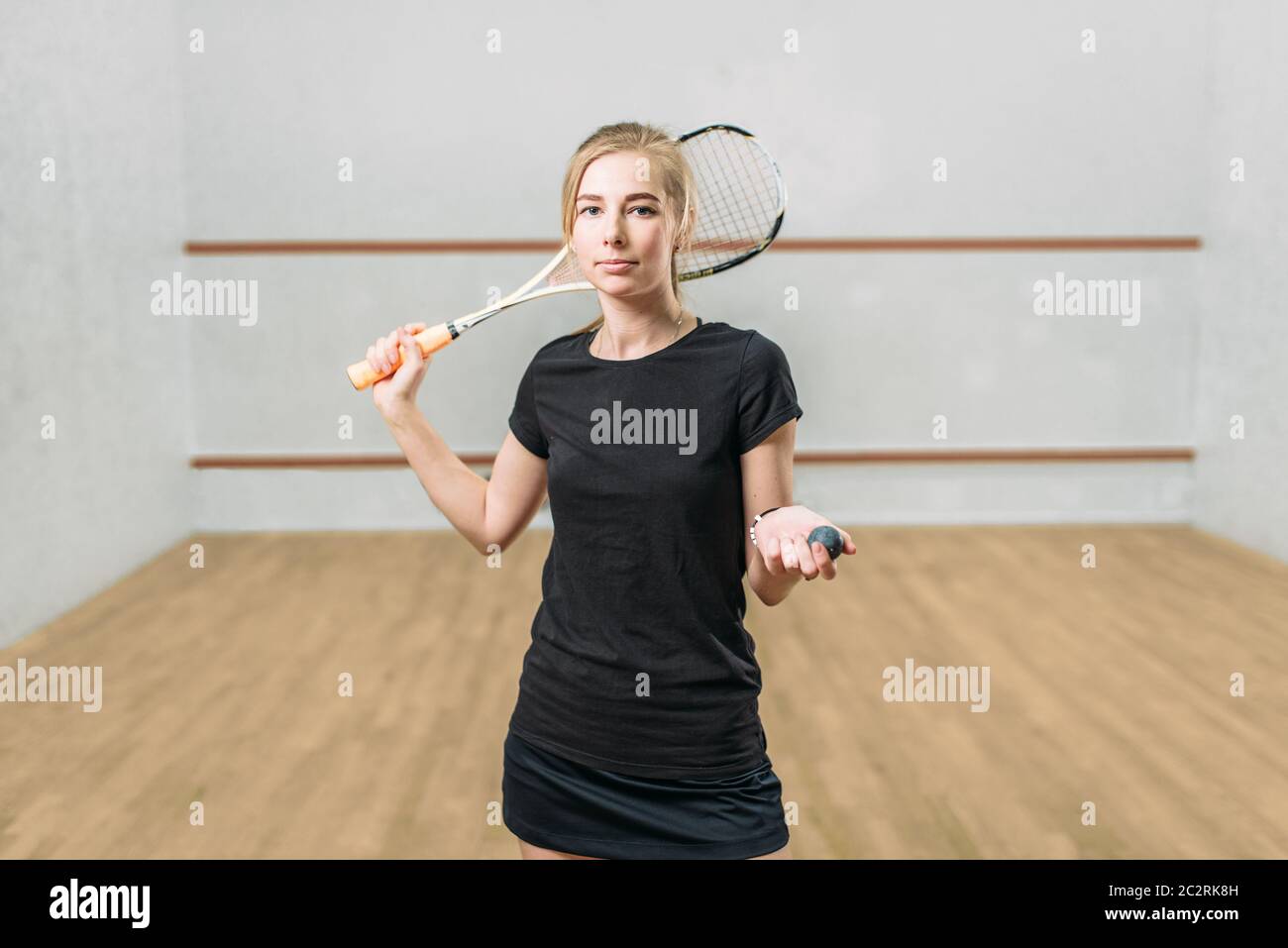 Squash game female player with racket and ball in hands, indoor ...