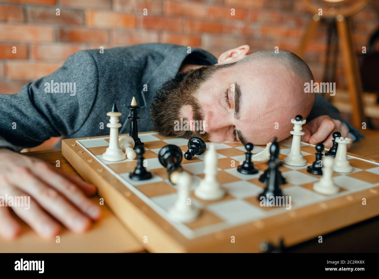 Tired male chess player sleeping on the board. Chessplayer playing ...
