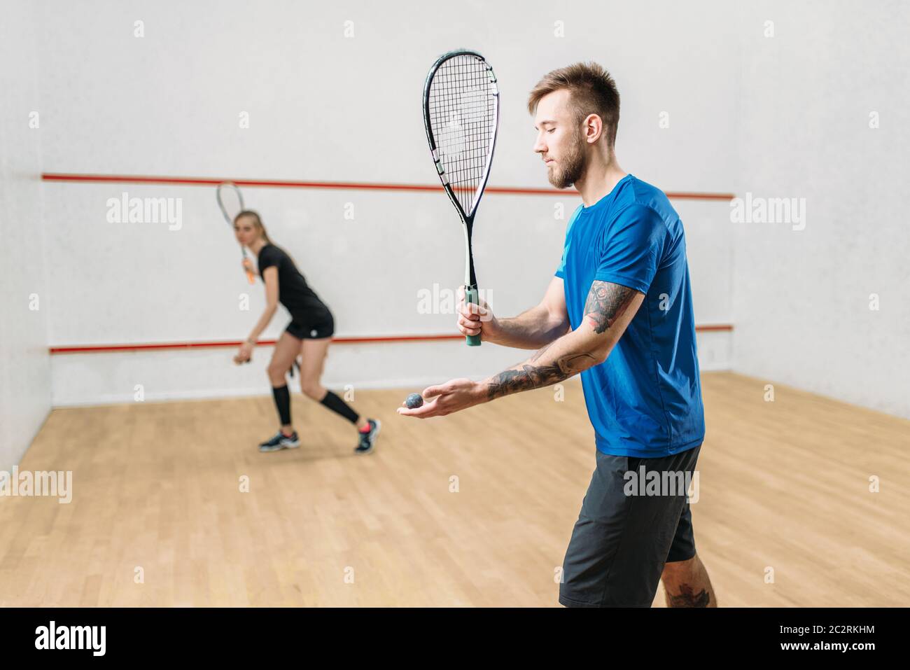Young couple with squash rackets, indoor training club. Active sport ...