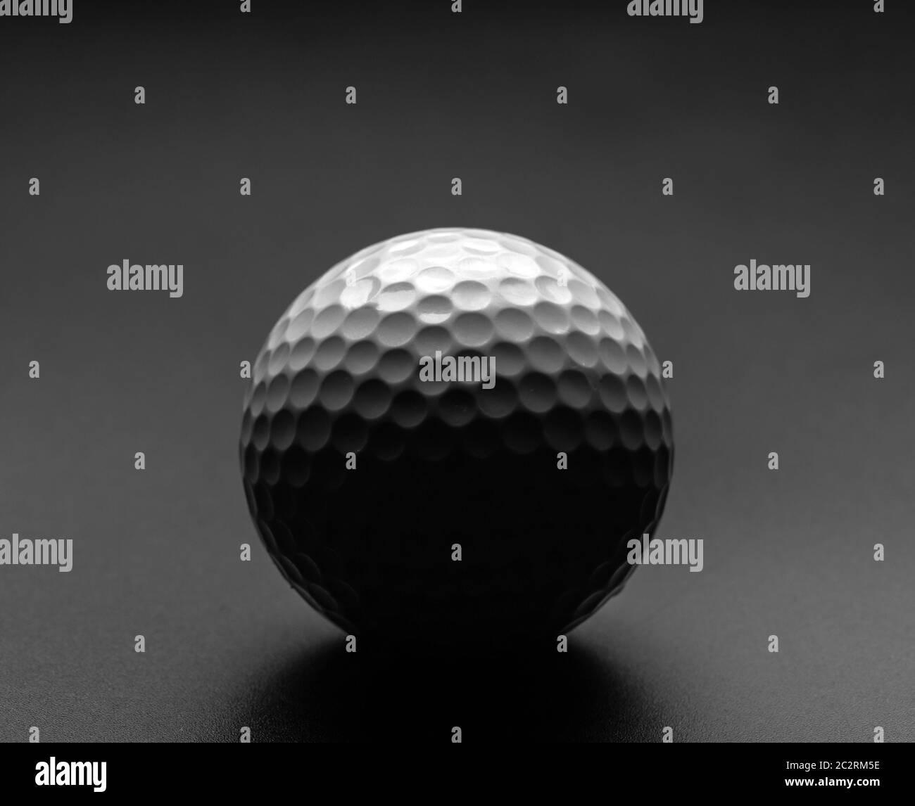 Golf ball with big shadow on grey background Stock Photo - Alamy