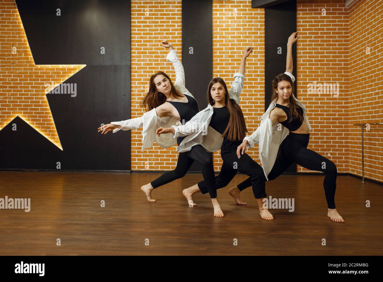 Contemporary dance performers posing in studio. Dancers training in ...