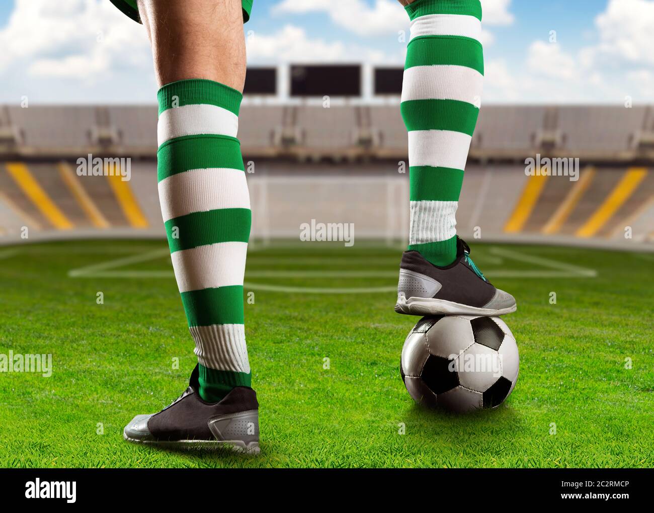Football player legs with a ball standing on the football stadium Stock ...