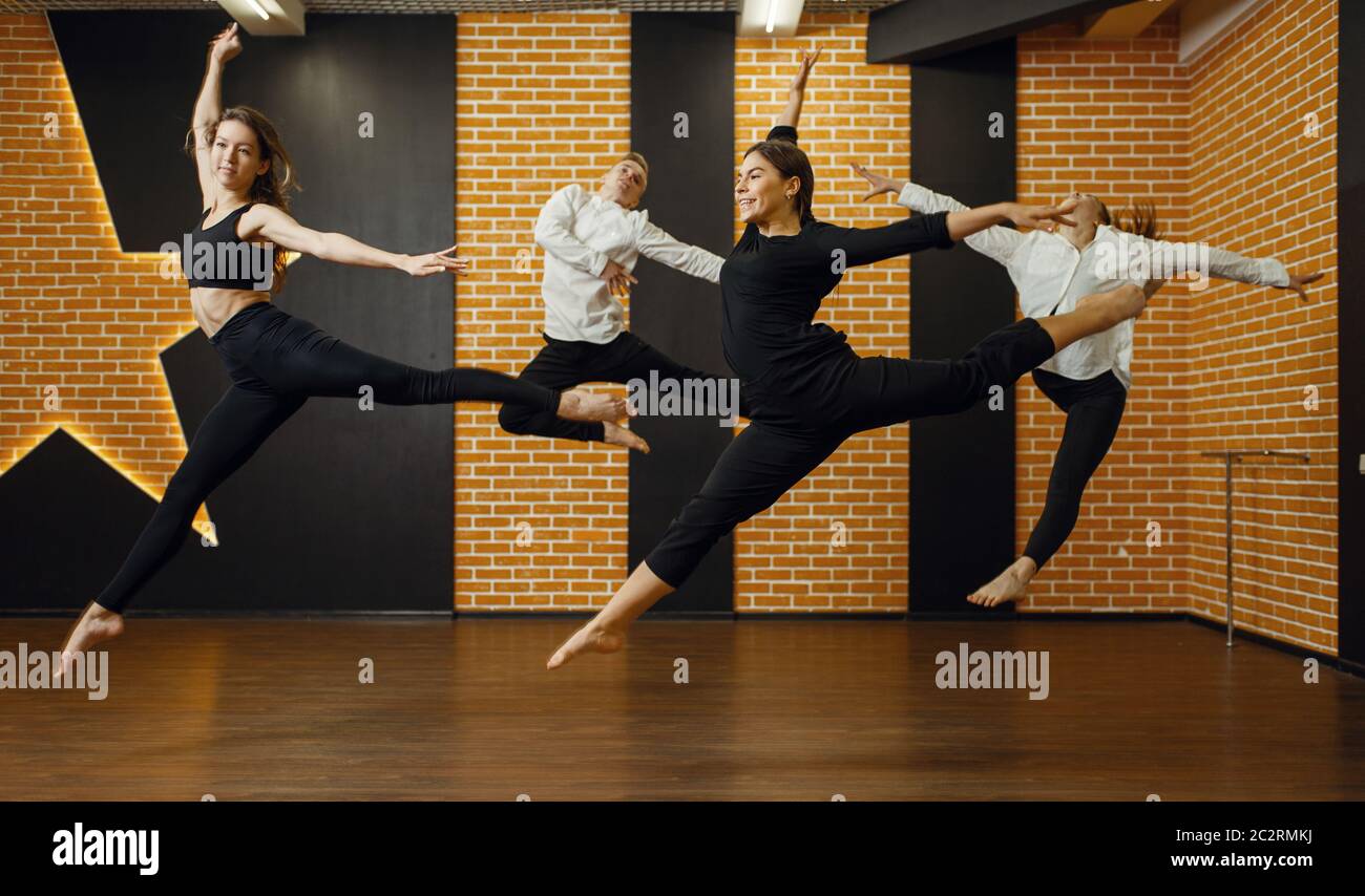 Contemporary dance studio, performers in jump. Female and male dancers ...