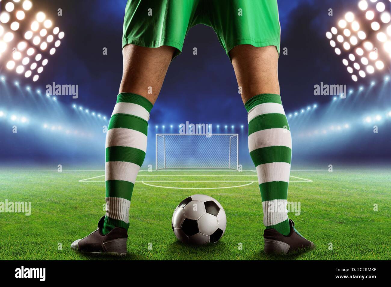 Football-player with a ball between his legs standing on the football ...
