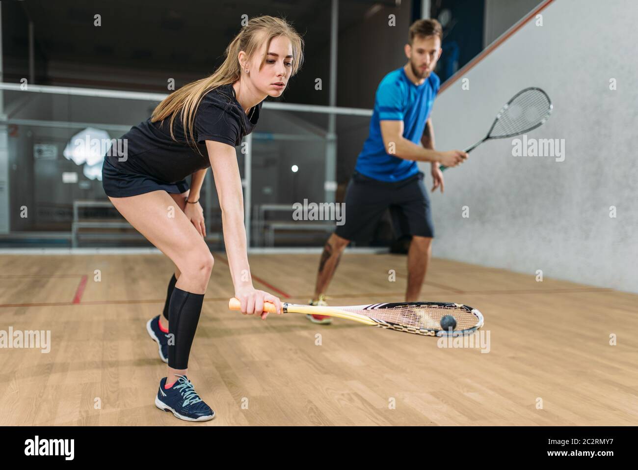 Young couple with squash rackets, indoor training club. Active sport ...