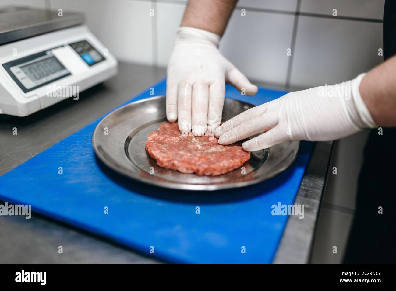 Chef hands in gloves prepares meat, burger cooking. Hamburger ...