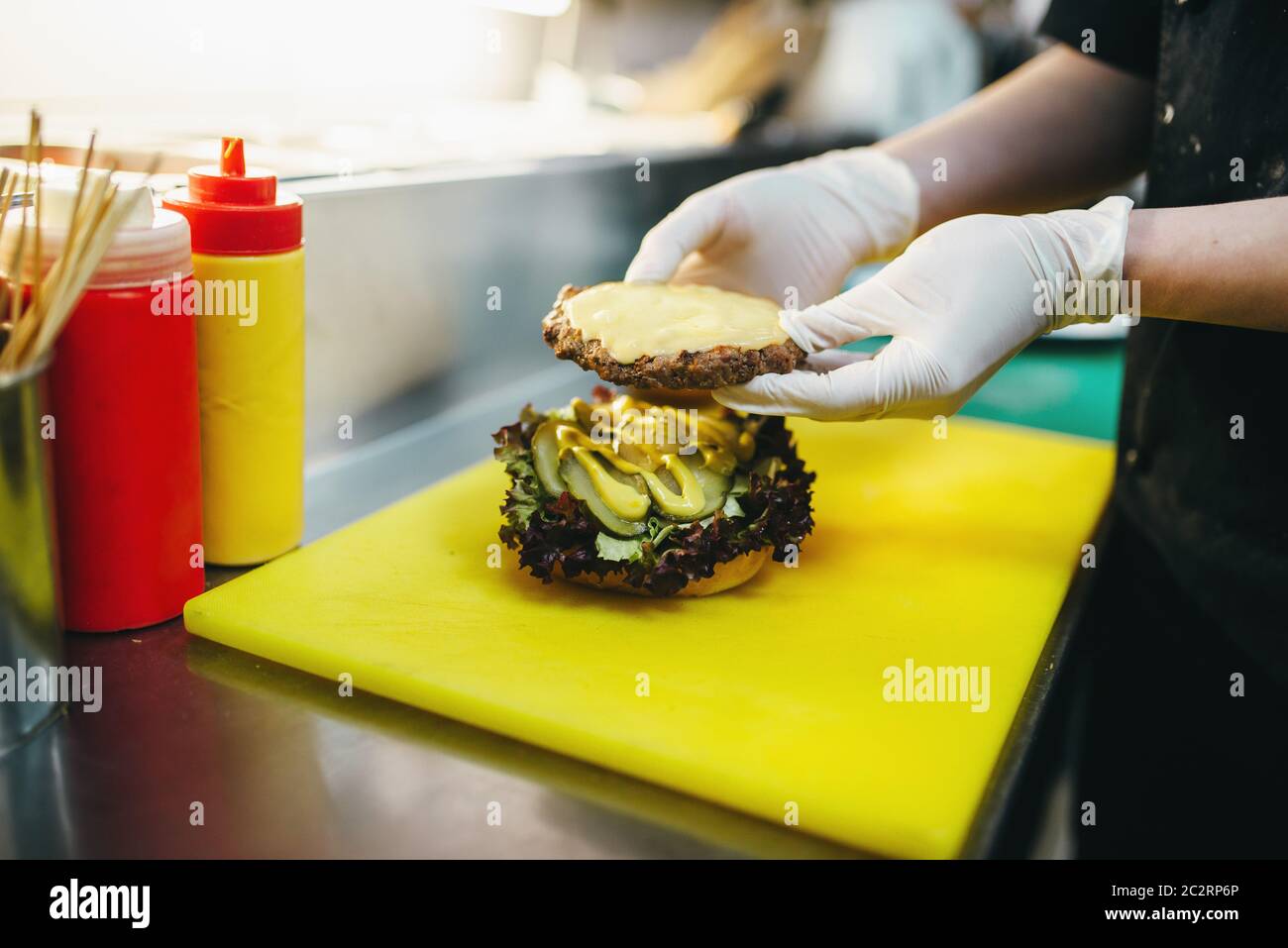 Male cook prepares fast food, burger preparation process. Fastfood ...