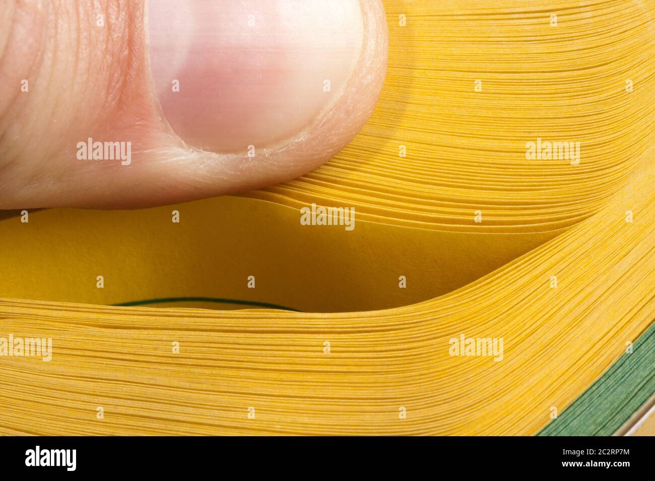 Hand searching the yellow pages with index finger Stock Photo - Alamy